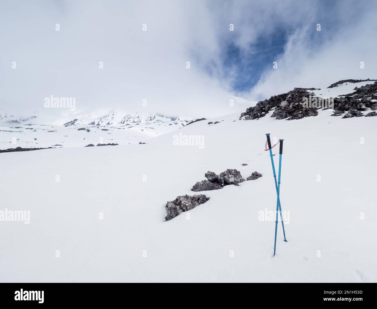 Pair of walking sticks in snow on slope of Plosky Tolbachik ...