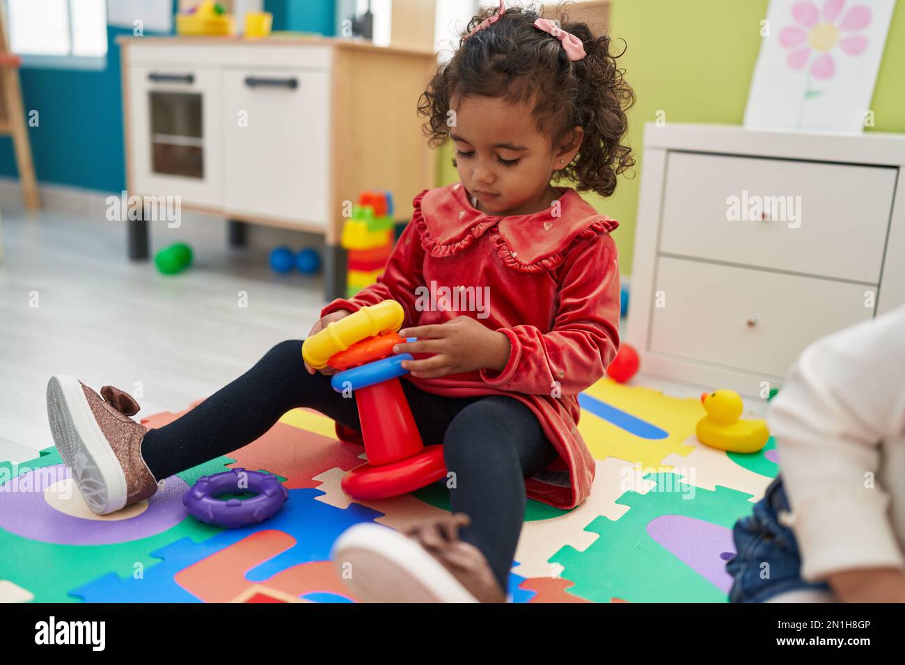 Adorable hispanic girl playing smiling confident sitting on floor at ...