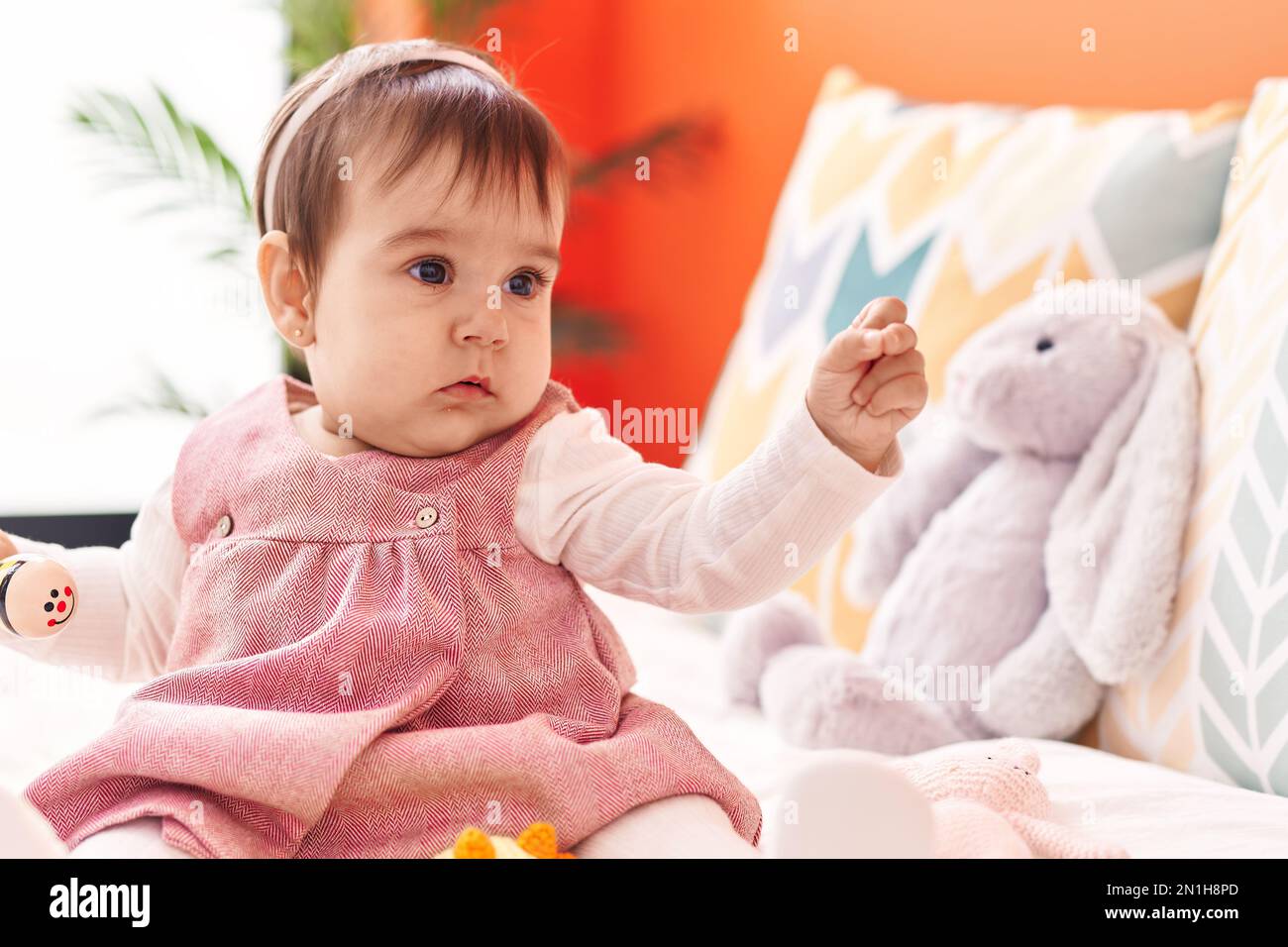 Adorable hispanic baby playing maraca sitting on bed at bedroom Stock ...