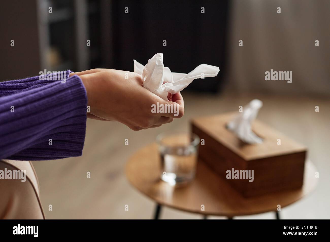 Hands of young woman holding paper tissue for wiping off tears when ...