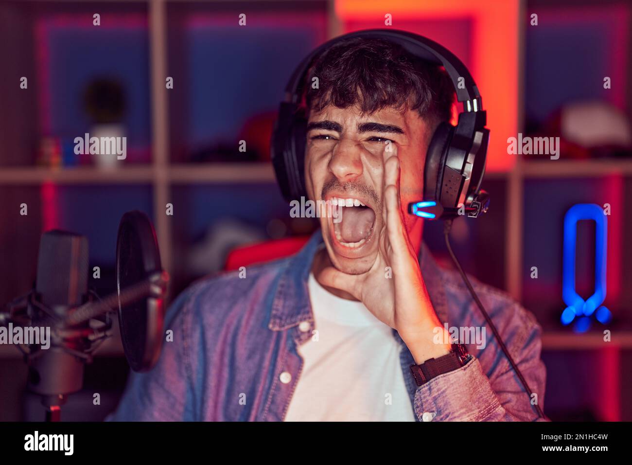 Young hispanic man playing video games clueless and confused with open ...