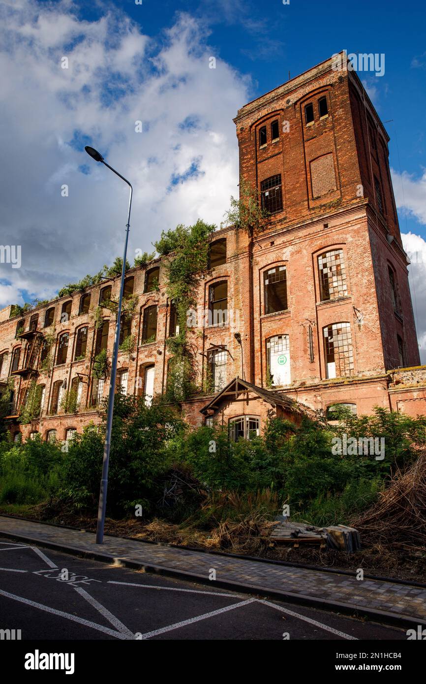 The building of an abandoned factory, red brick and broken glass in the ...