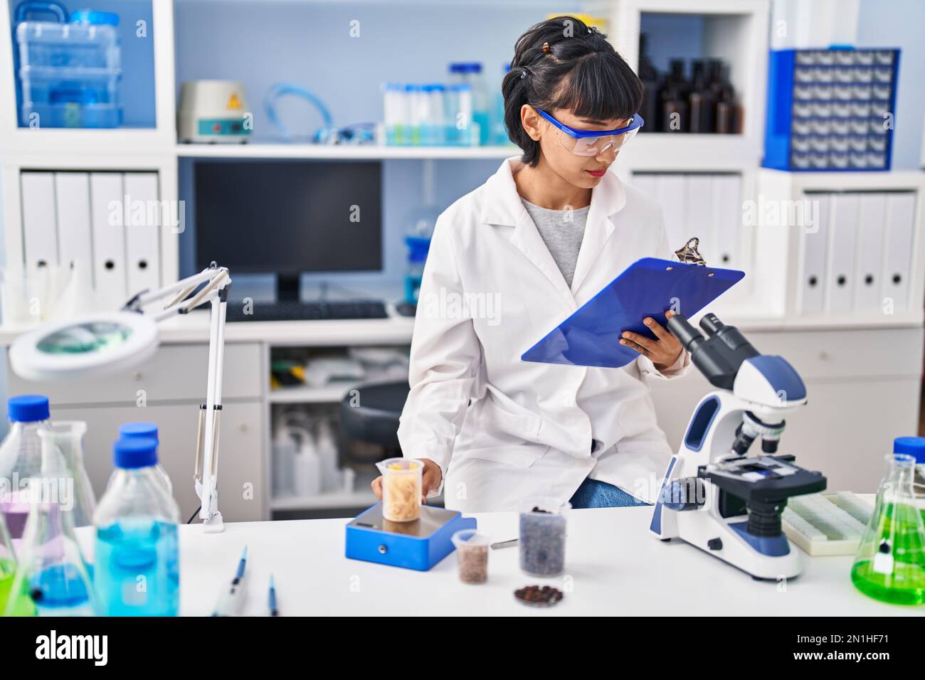 Young woman scientist measuring liquid at laboratory Stock Photo - Alamy