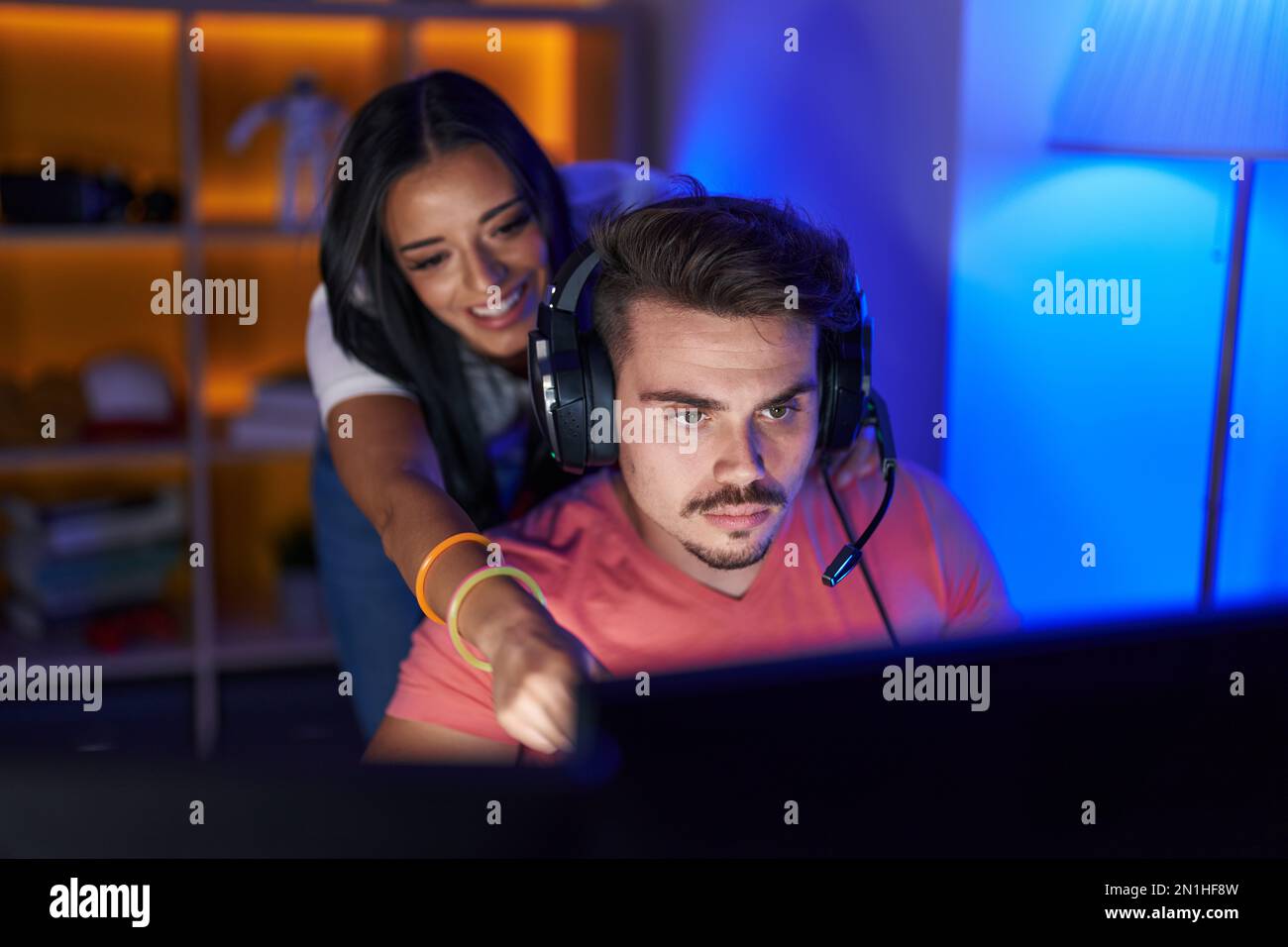 Man and woman streamers playing video game using computer at gaming ...