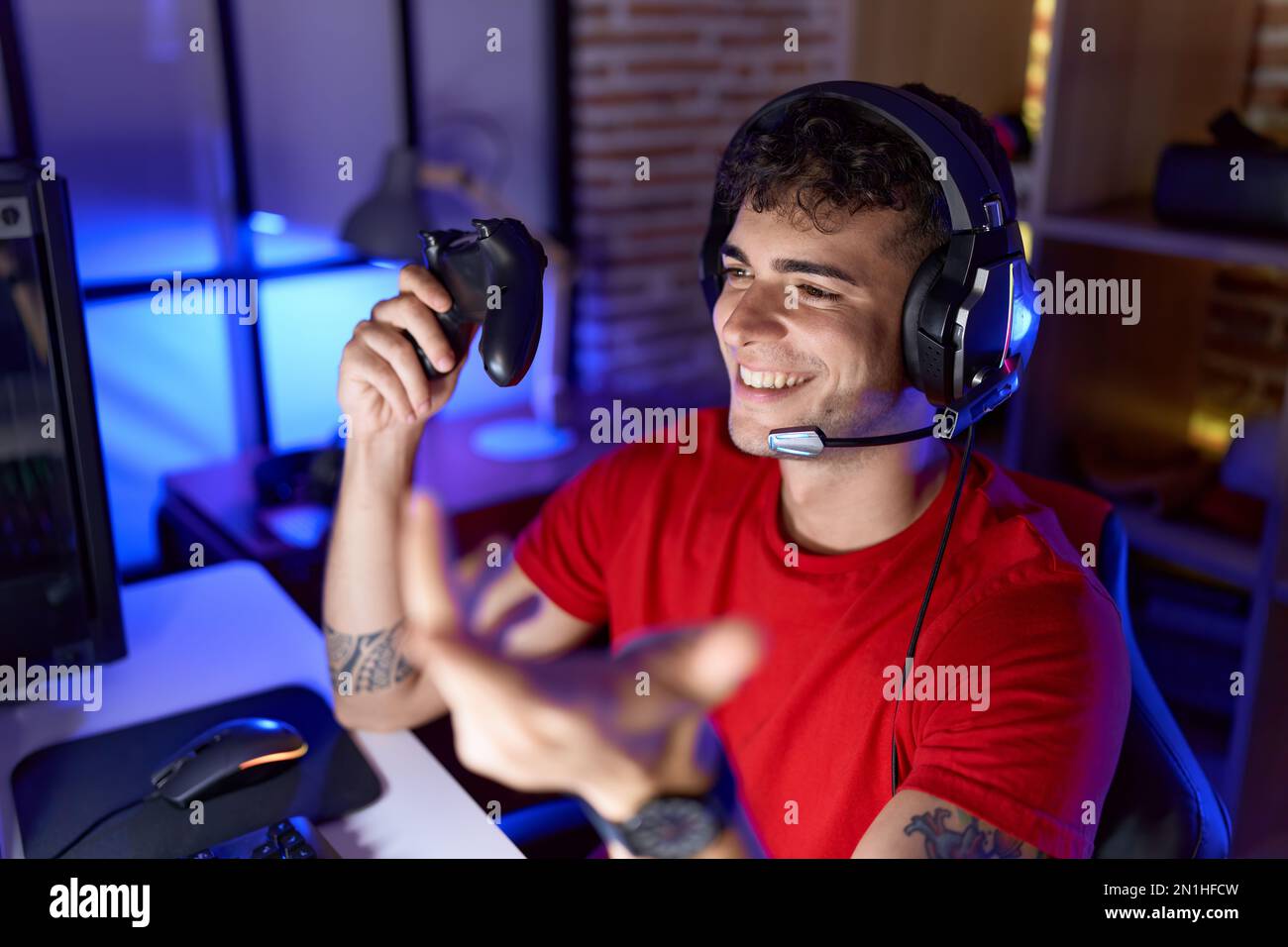 Young hispanic man streamer playing video game using joystick at gaming ...
