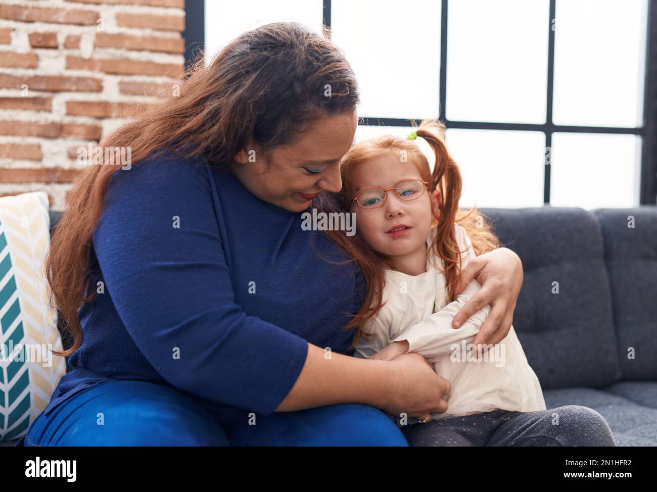 Teacher and student hugging each other sitting on sofa at home Stock ...
