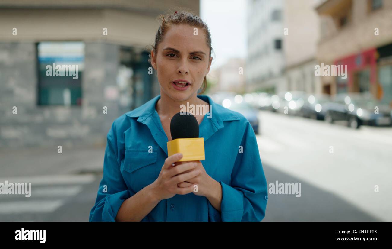 Young woman reporter working using microphone at street Stock Photo - Alamy