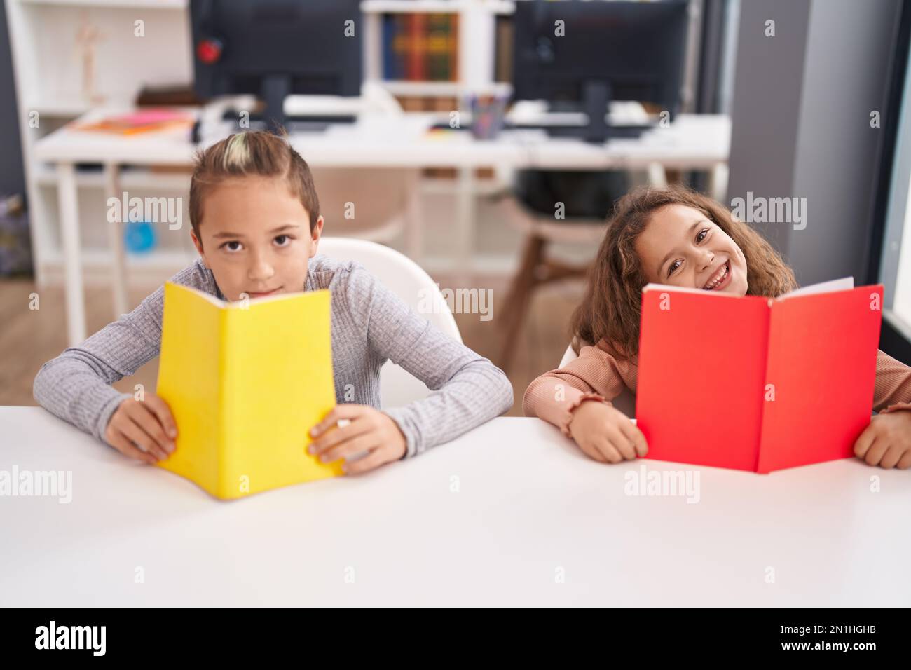 Two kids students reading book studying at classroom Stock Photo - Alamy