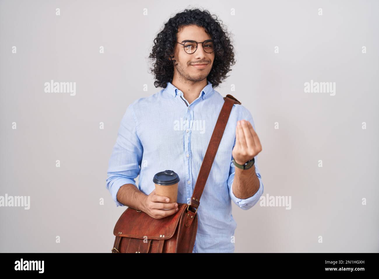 Hispanic man with curly hair drinking a cup of take away coffee doing ...