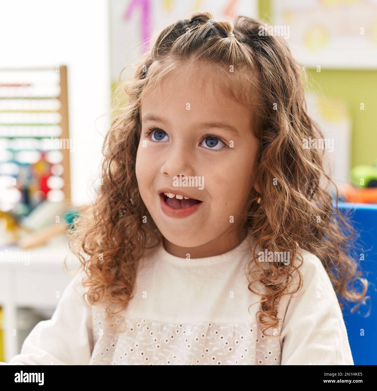Adorable blonde toddler smiling confident sitting on chair at kindergarten Stock Photo - Alamy