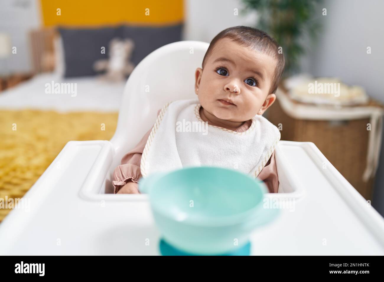 Adorable hispanic baby wearing bib sitting on highchair at bedroom Stock Photo - Alamy