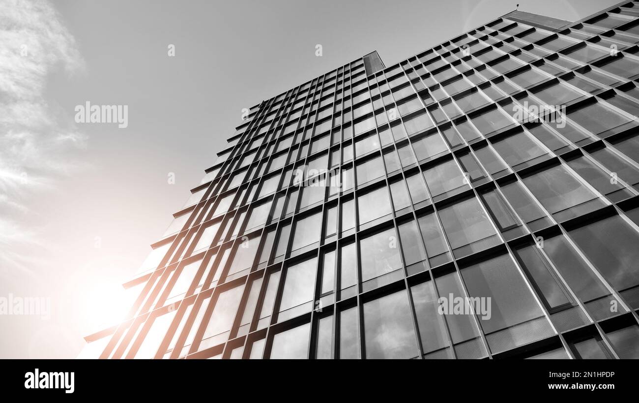 Bottom view of modern skyscraper in business district against blue sky ...