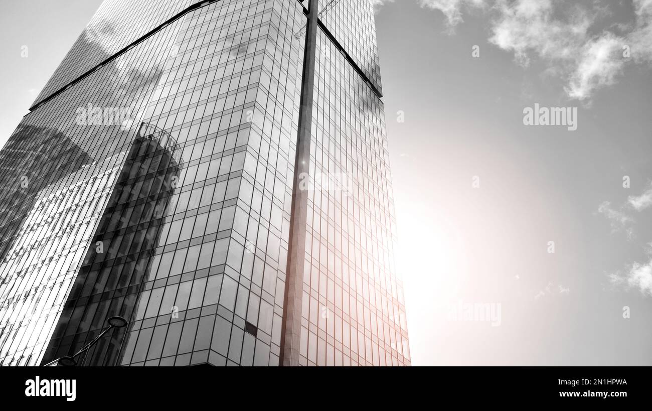 Bottom view of modern skyscraper in business district against blue sky ...