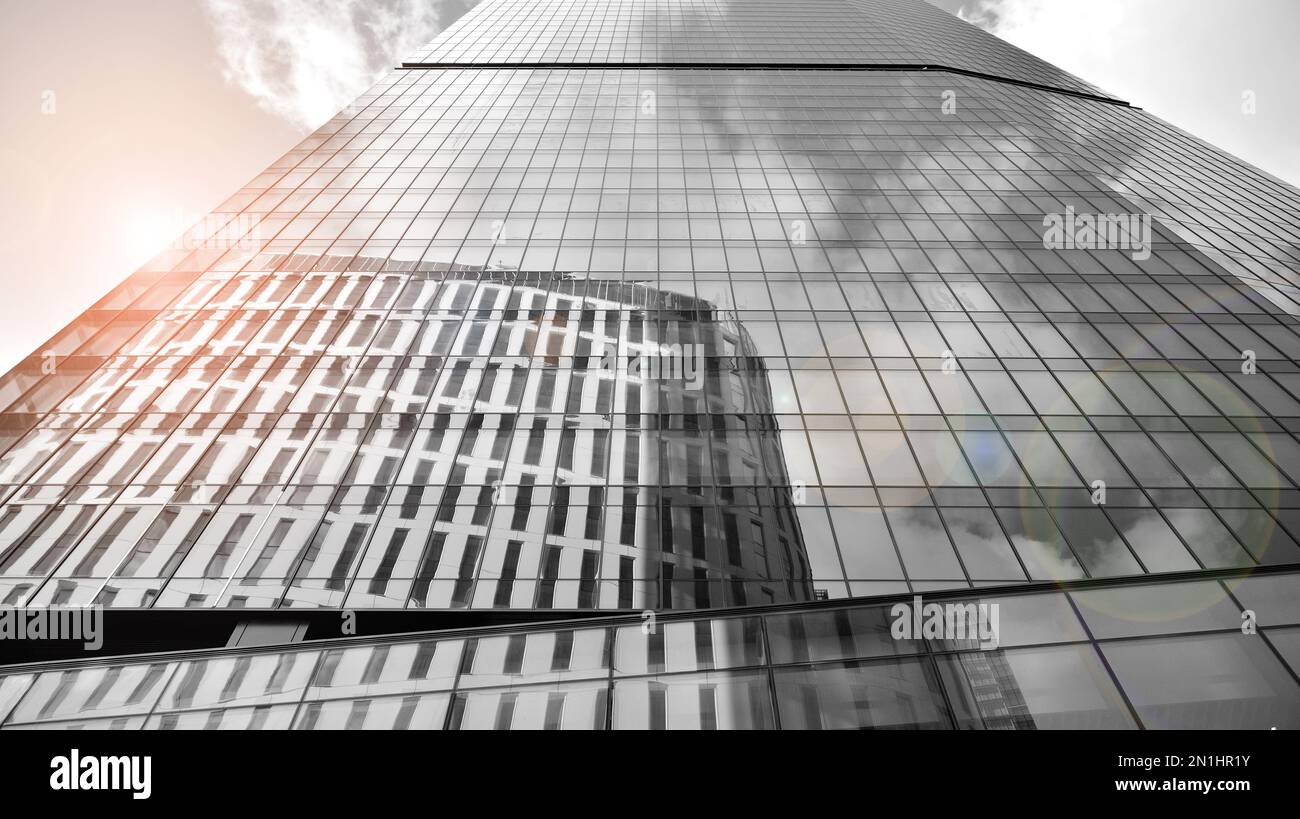 Bottom view of modern skyscraper in business district against blue sky ...