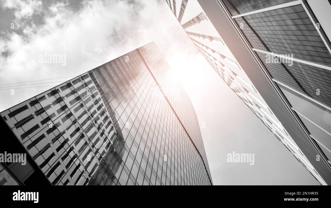 Bottom view of modern skyscraper in business district against blue sky ...