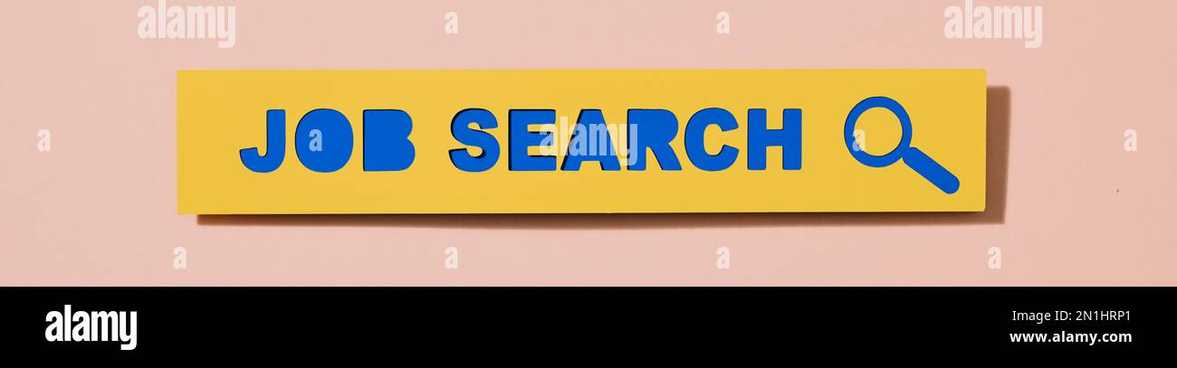 a yellow paper sign that reads job search in blue, on a pale pink ...