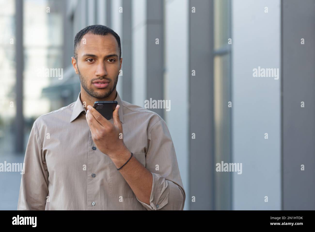 Angry businessman in shirt recording audio message from outside office ...