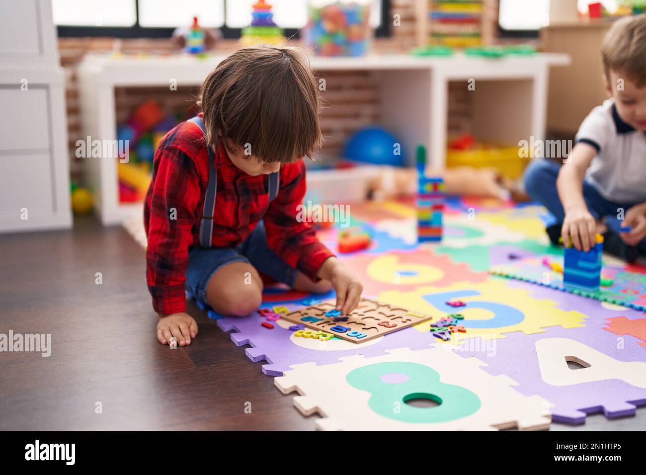 Two kids playing with construction blocks and maths puzzle game sitting ...