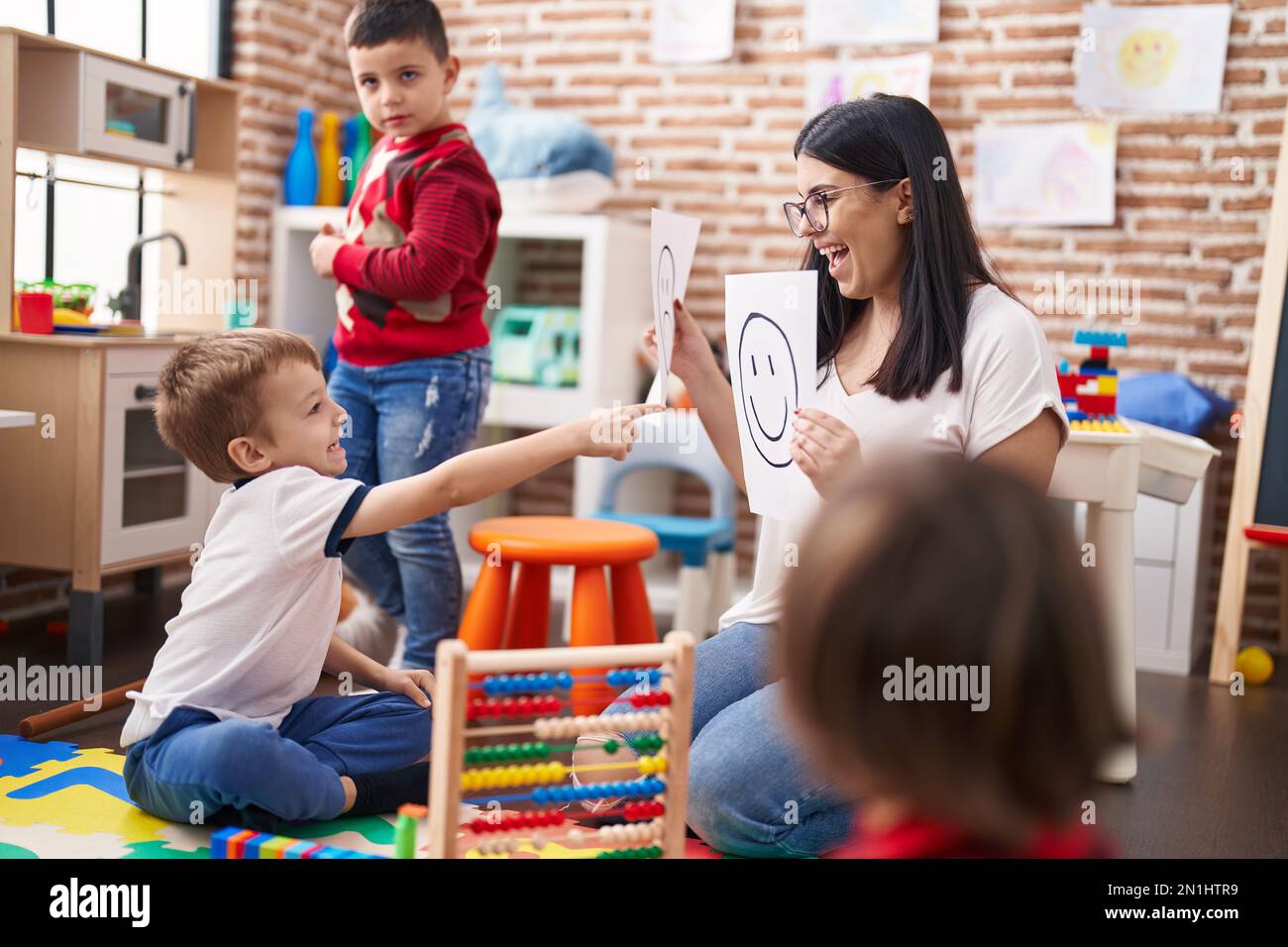 Teacher with group of boys sitting on table having emotion therapy at ...