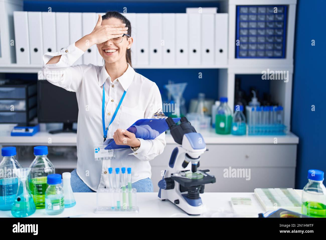 Young brunette woman working at scientist laboratory smiling and ...