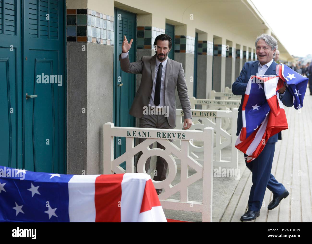 The mayor of Deauville Philippe Augier, right reacts with actor Keanu ...