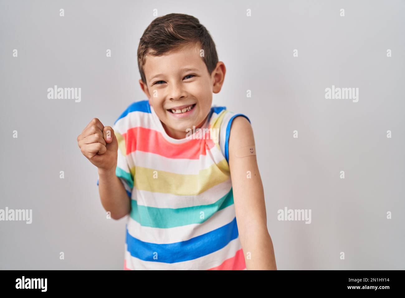 Young caucasian kid getting vaccine showing arm with band aid screaming ...