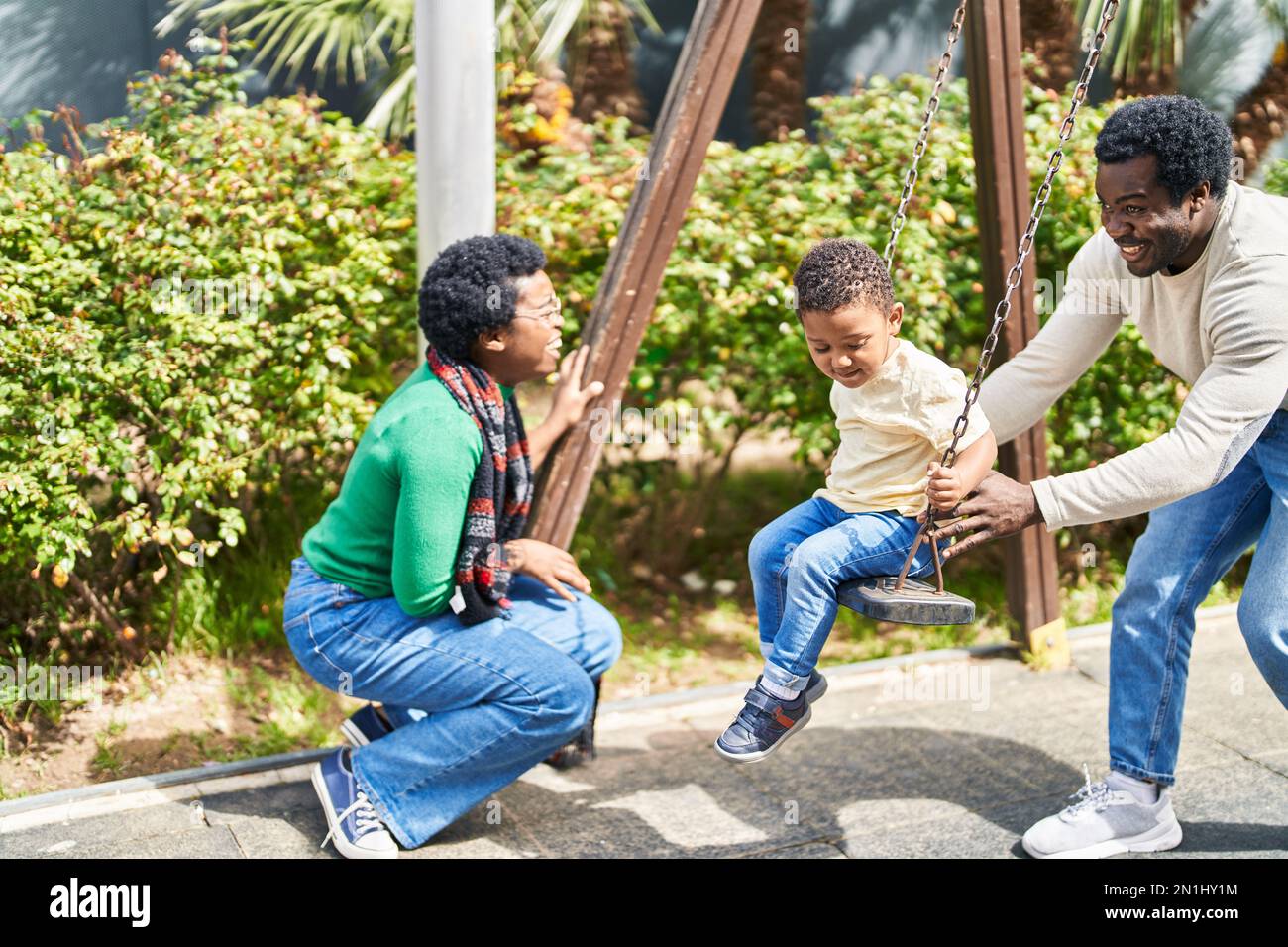 African american family playing on swing at playground Stock Photo - Alamy