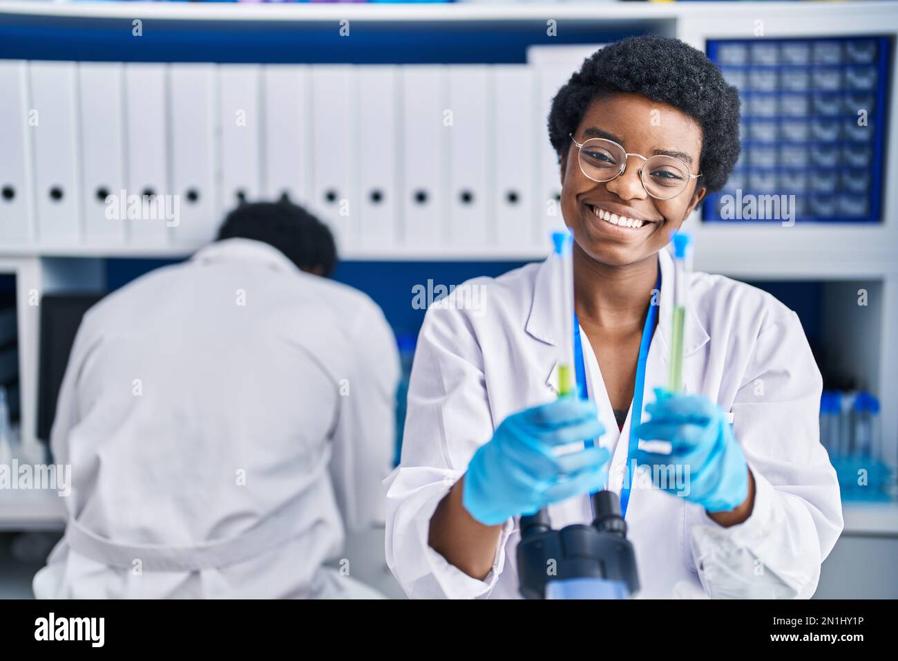 African american man and woman scientists holding test tubes at ...
