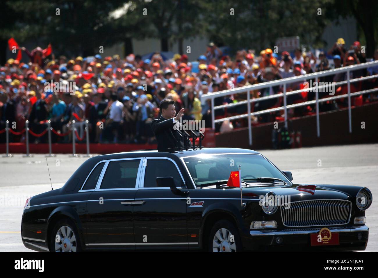 Chinese President Xi Jinping waves from a limousine after inspecting a ...