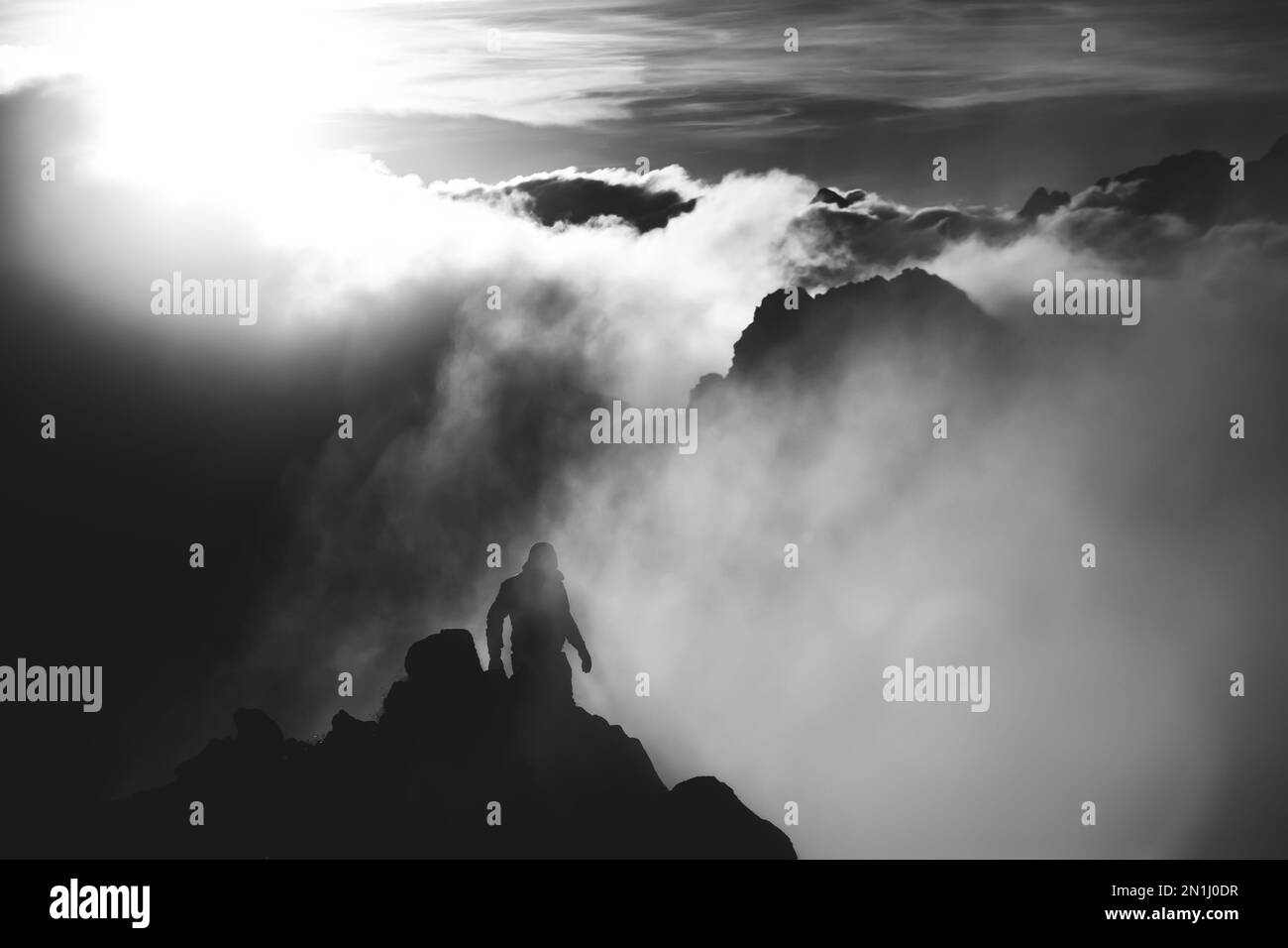 A mountain climber at the summit during sunrise in the Tatra mountains ...