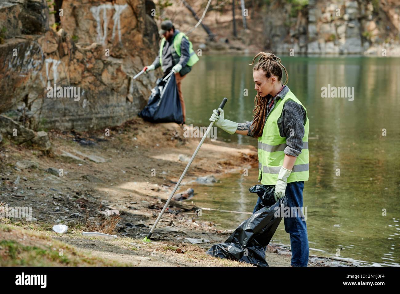 Criminal cleaning lakeshore as part of community service sentence Stock ...