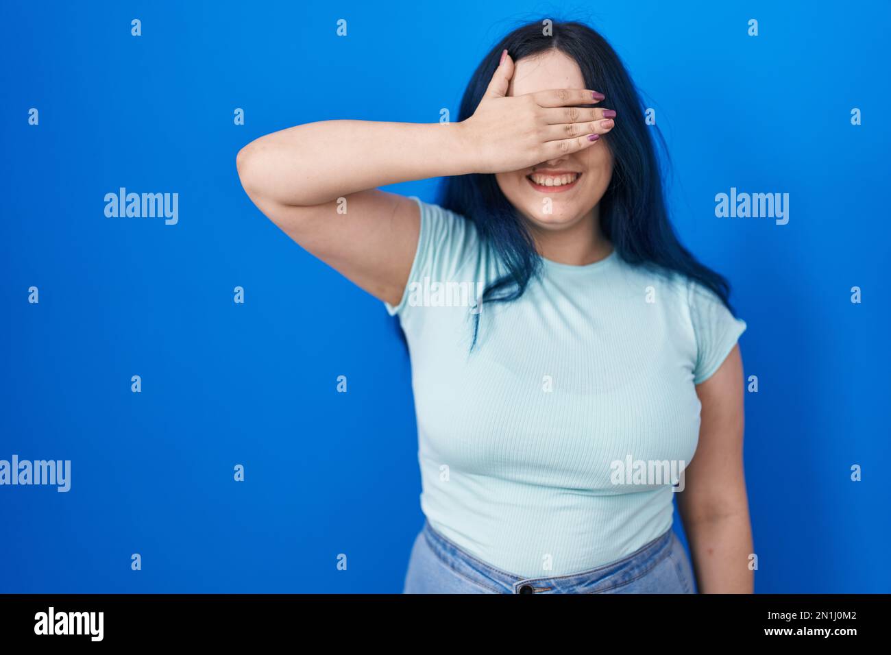Young Modern Girl With Blue Hair Standing Over Blue Background Smiling 5089