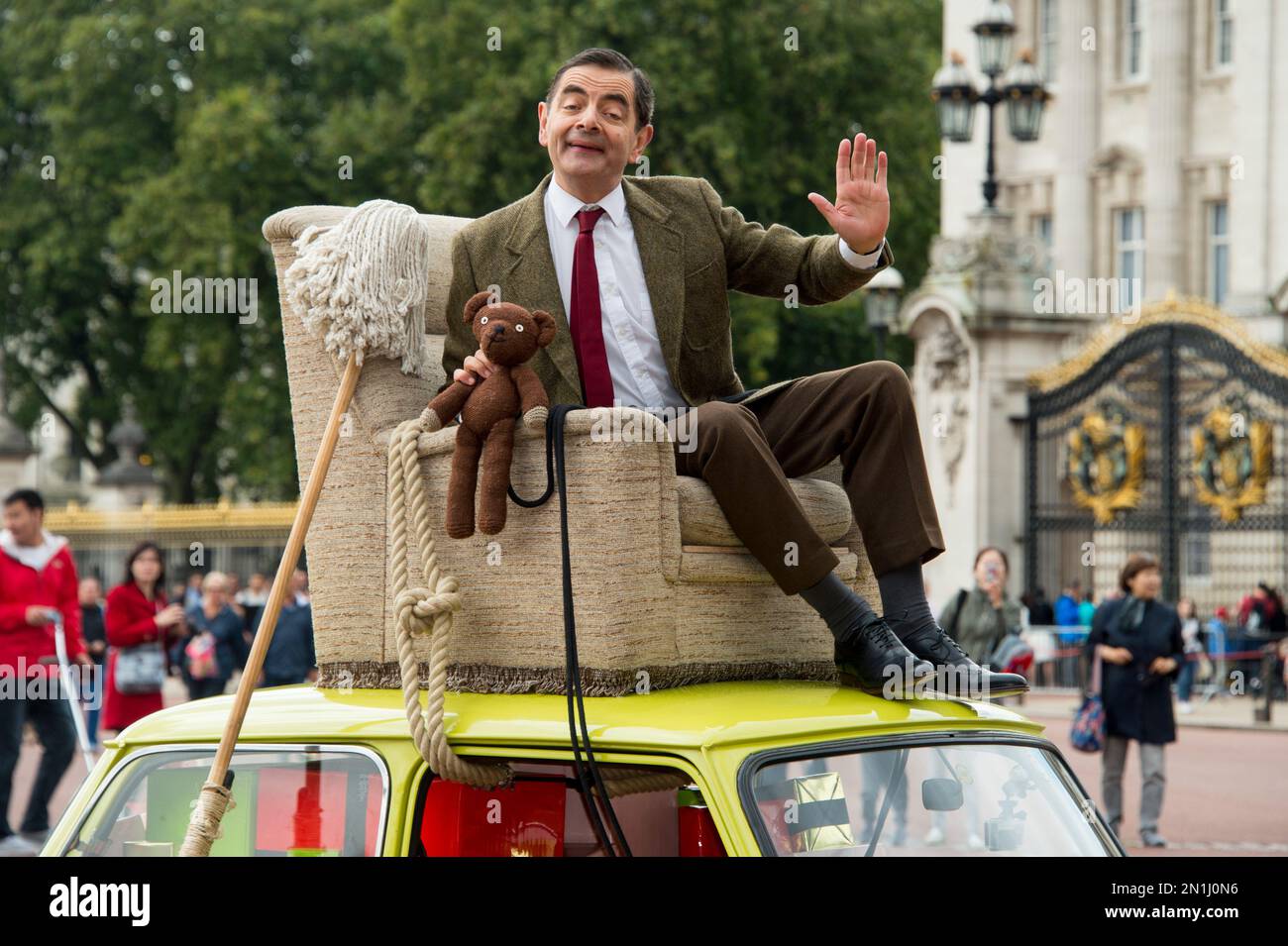 British actor Rowan Atkinson, dressed as Mr Bean, sits on top of a Mini ...