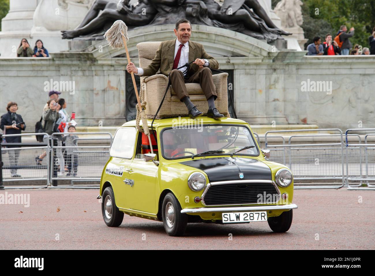 British actor Rowan Atkinson, dressed as Mr Bean, sits on top of a Mini ...