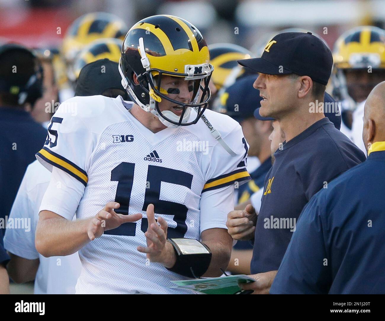 Michigan quarterback Jake Rudock (15) speaks head coach Jim Harbaugh in ...