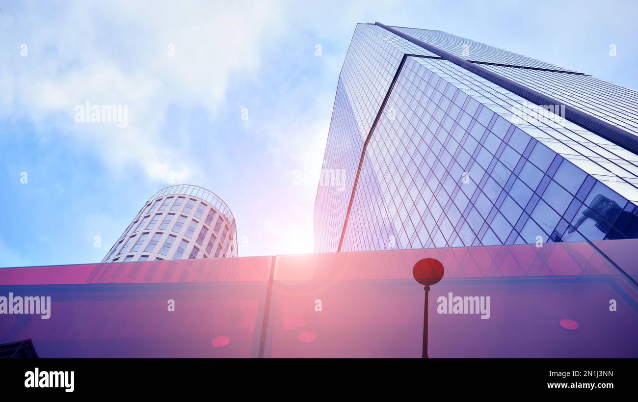 Modern glass facade against blue sky. Bottom view of a building in the ...