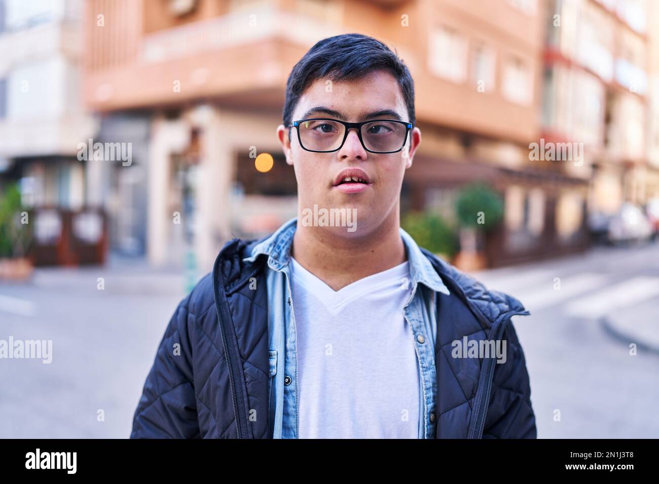 Down syndrome man with relaxed expression standing at street Stock ...