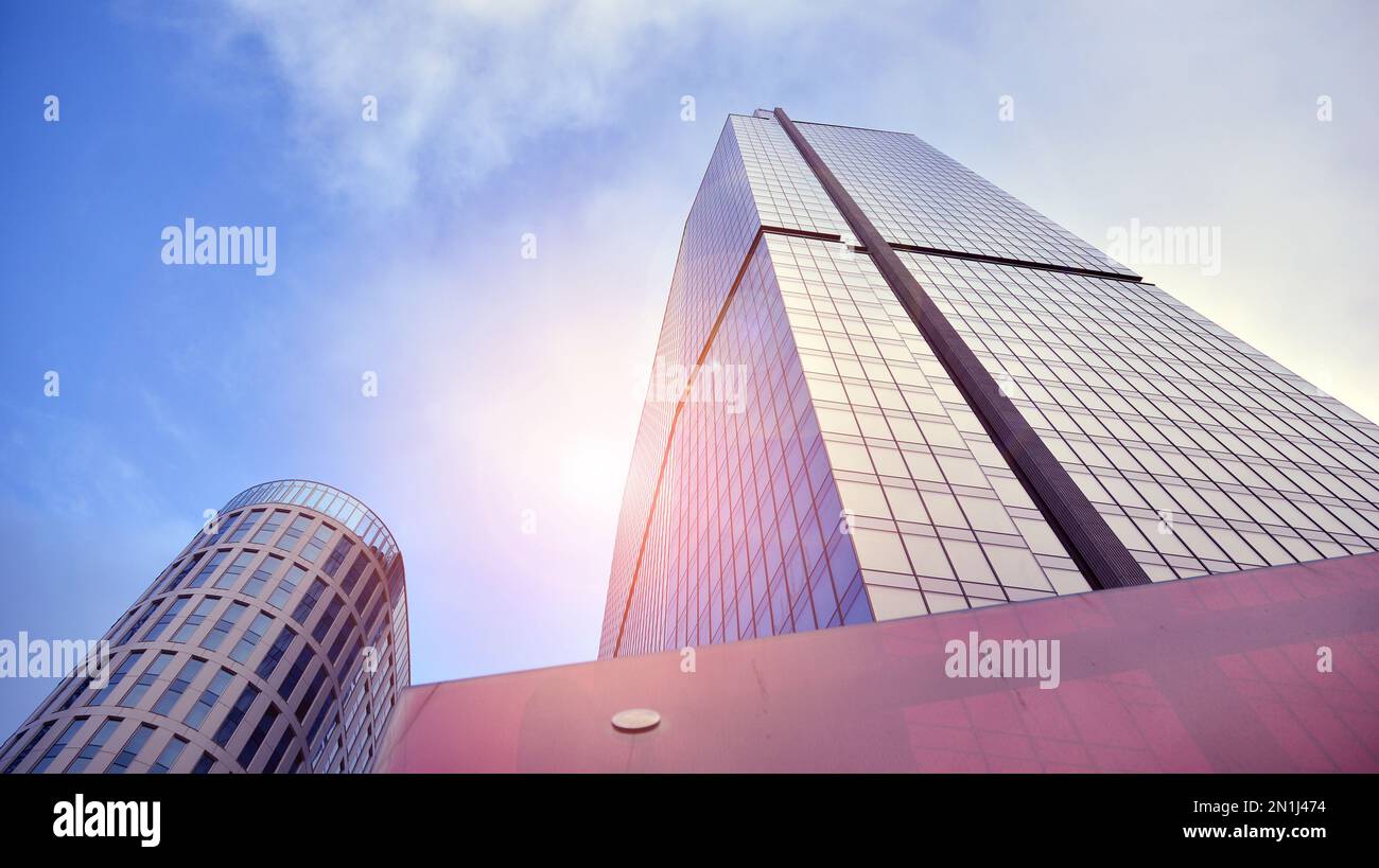 Modern glass facade against blue sky. Bottom view of a building in the ...