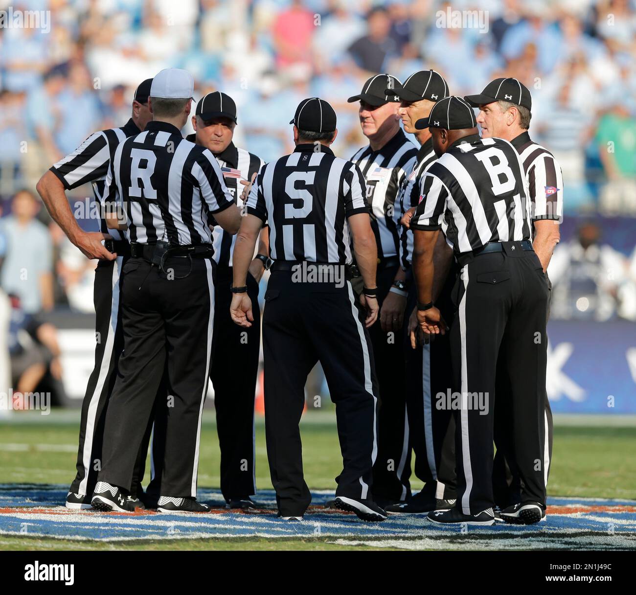 Officials meet at midfield before the first half of an NCAA college ...