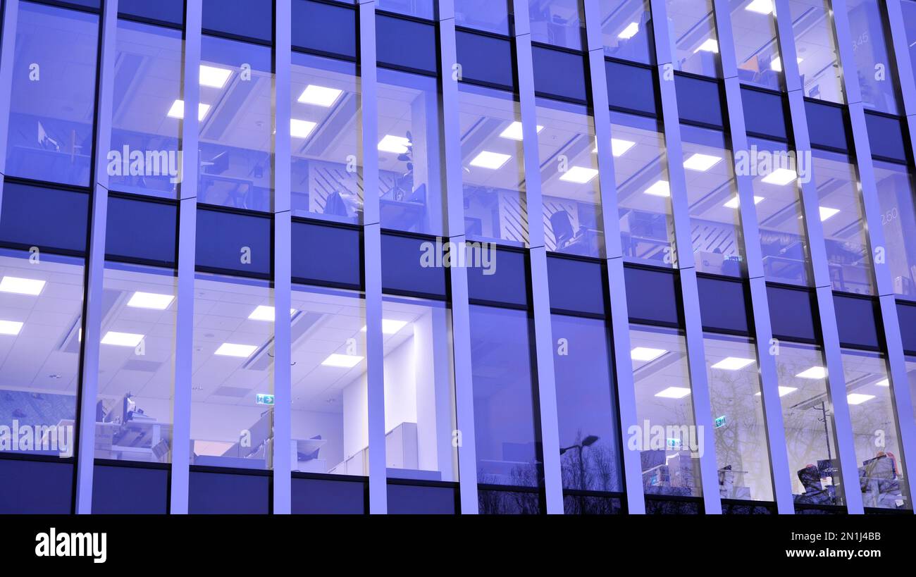 Pattern of office buildings windows illuminated at night. Lighting with ...