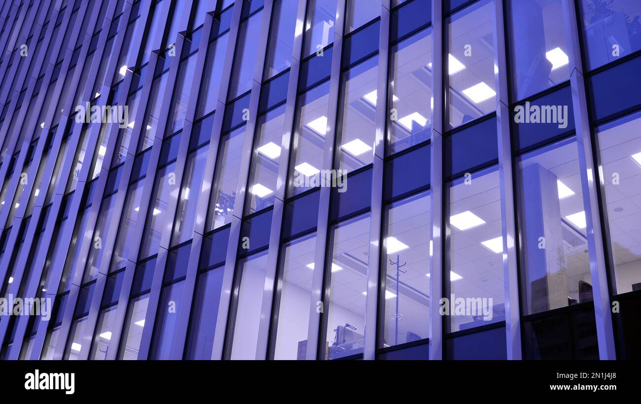 Pattern of office buildings windows illuminated at night. Lighting with ...