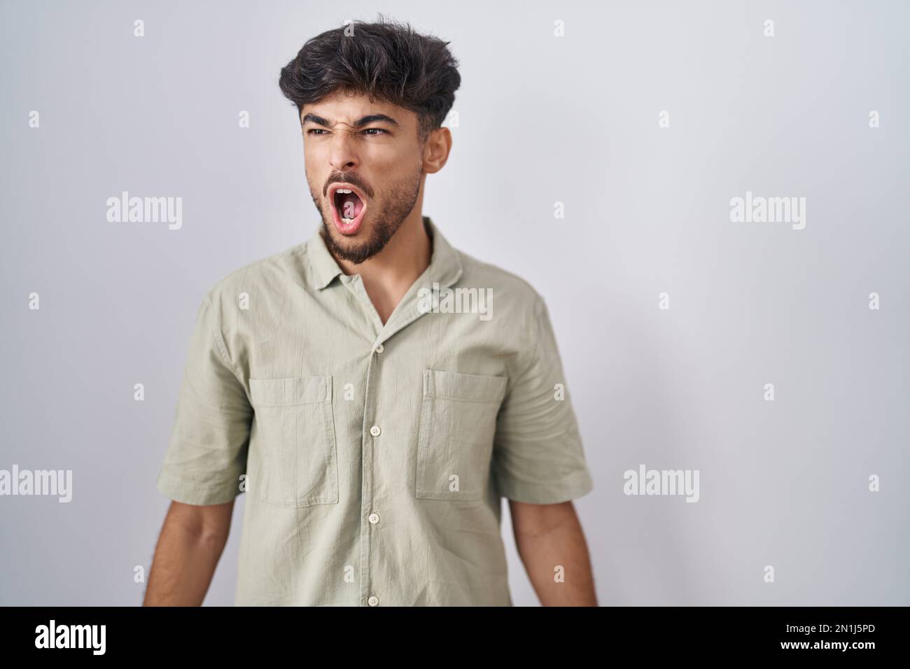 Arab man with beard standing over white background angry and mad ...