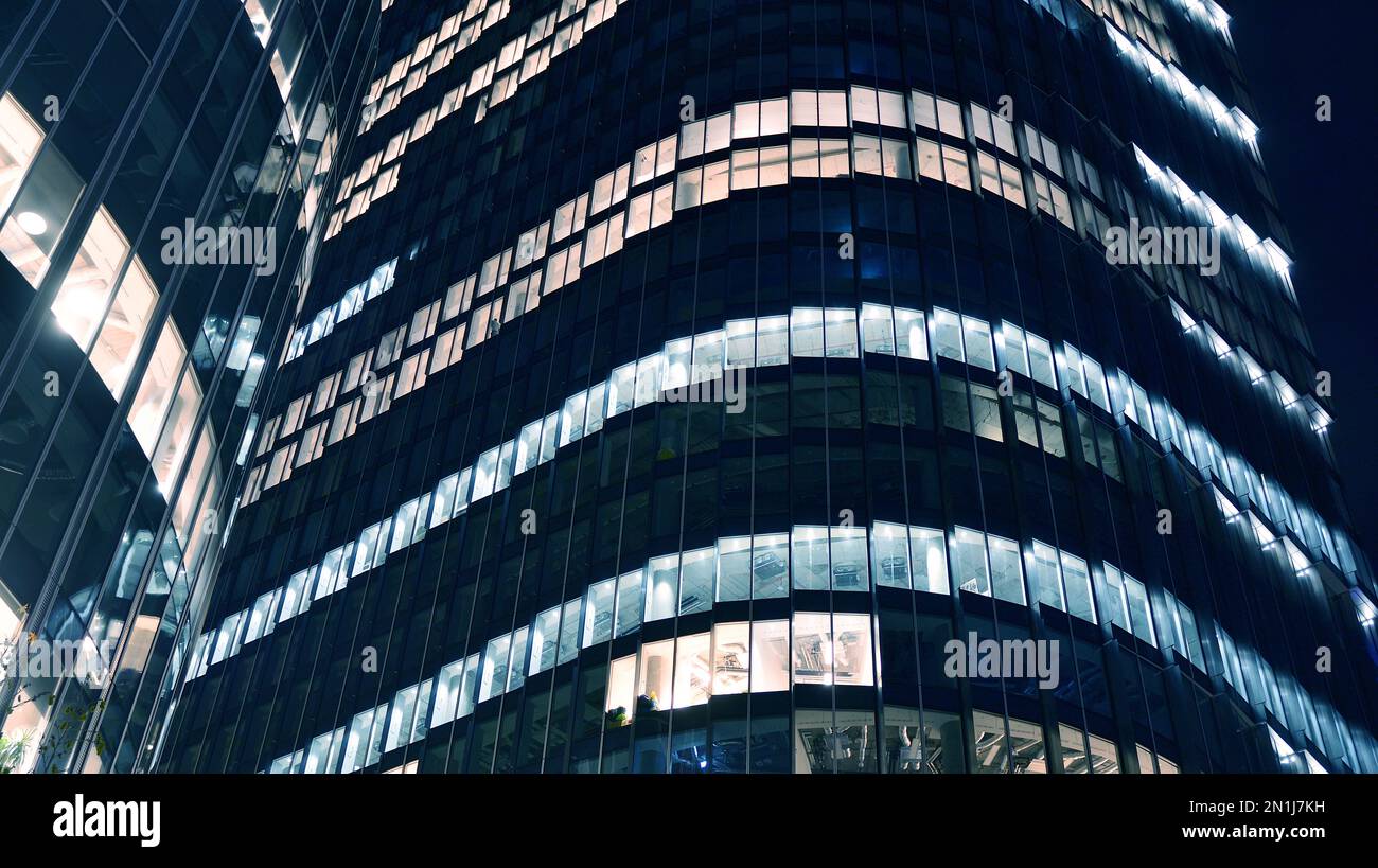 Pattern of office buildings windows illuminated at night. Lighting with ...