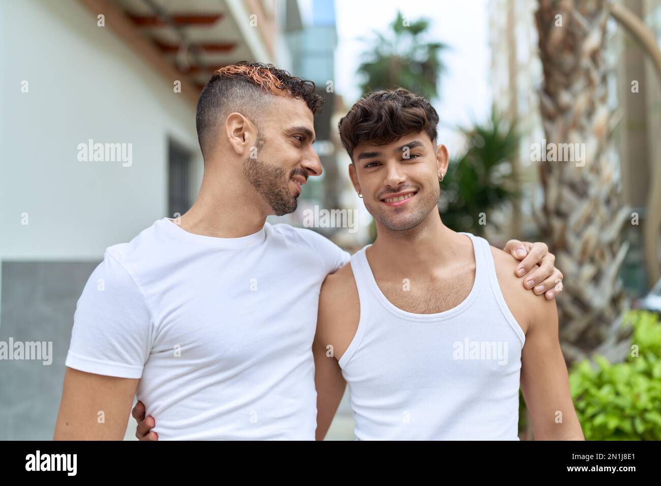 Two hispanic men couple smiling confident hugging each other at street ...