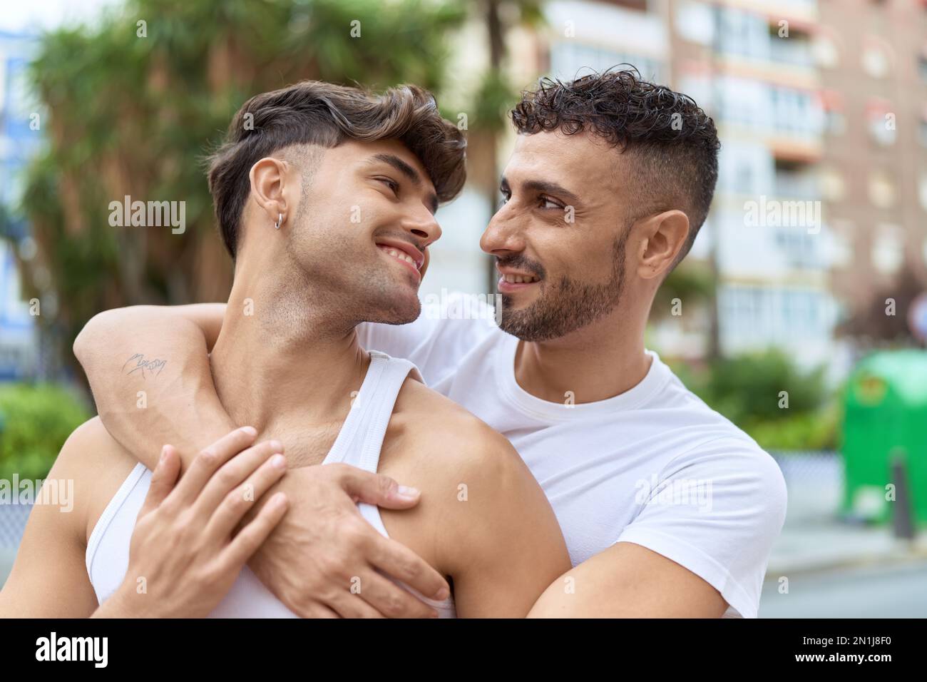 Two hispanic men couple smiling confident hugging each other at street ...