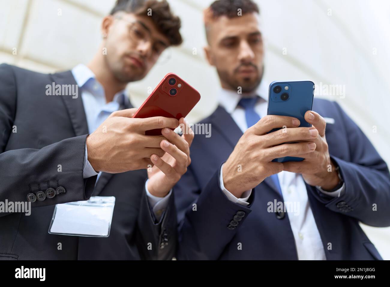 Two hispanic men business workers using smartphones at street Stock ...