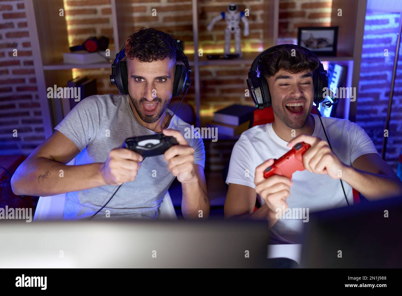 Two hispanic men streamers playing video game using joystick at gaming ...