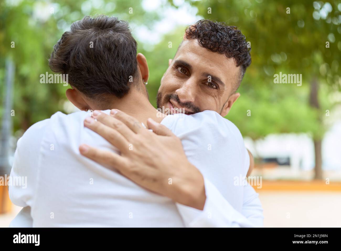Two hispanic men couple smiling confident hugging each other at park ...