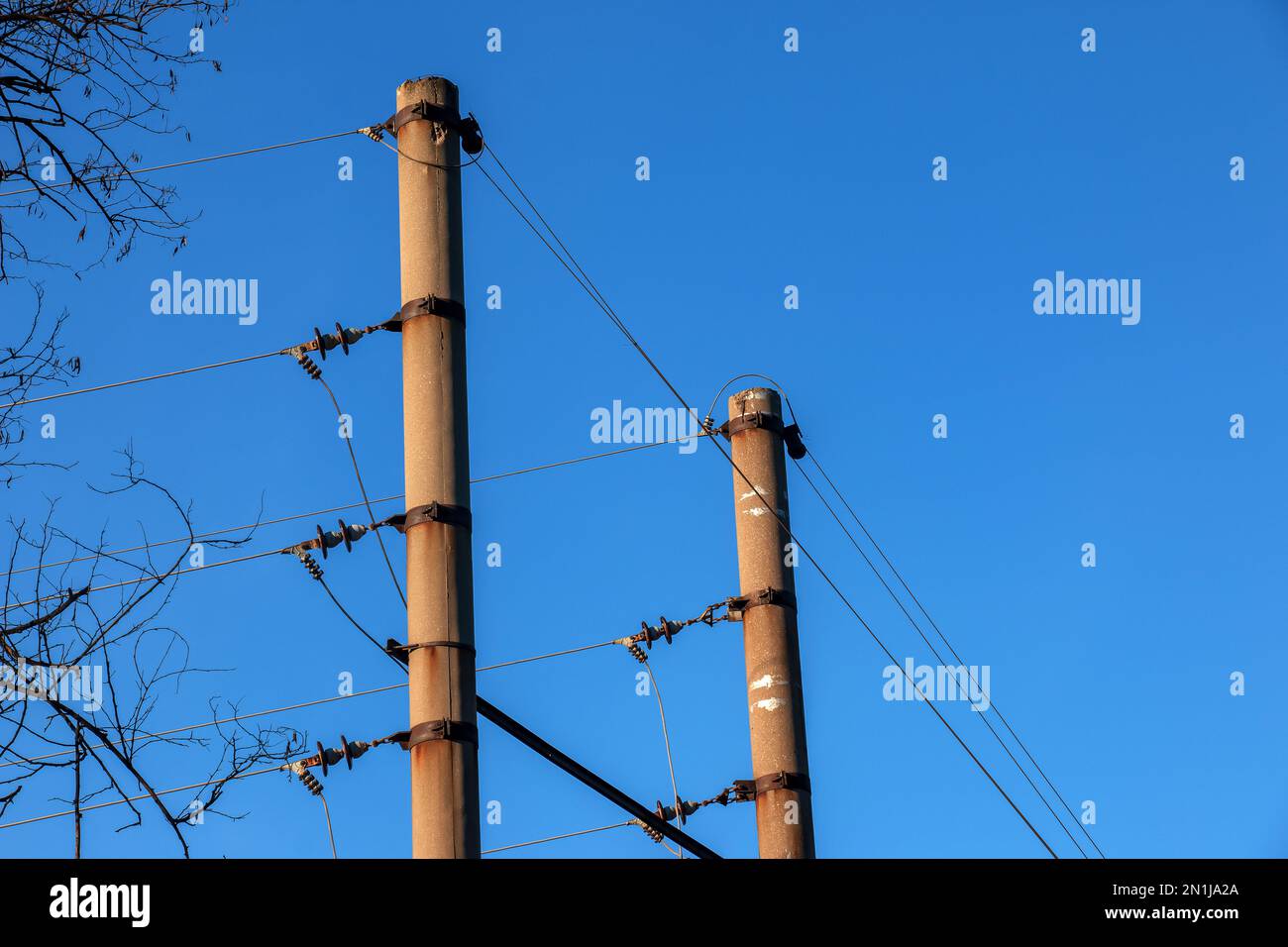 Electric pole with a linear wire against the blue sky close-up. Power ...