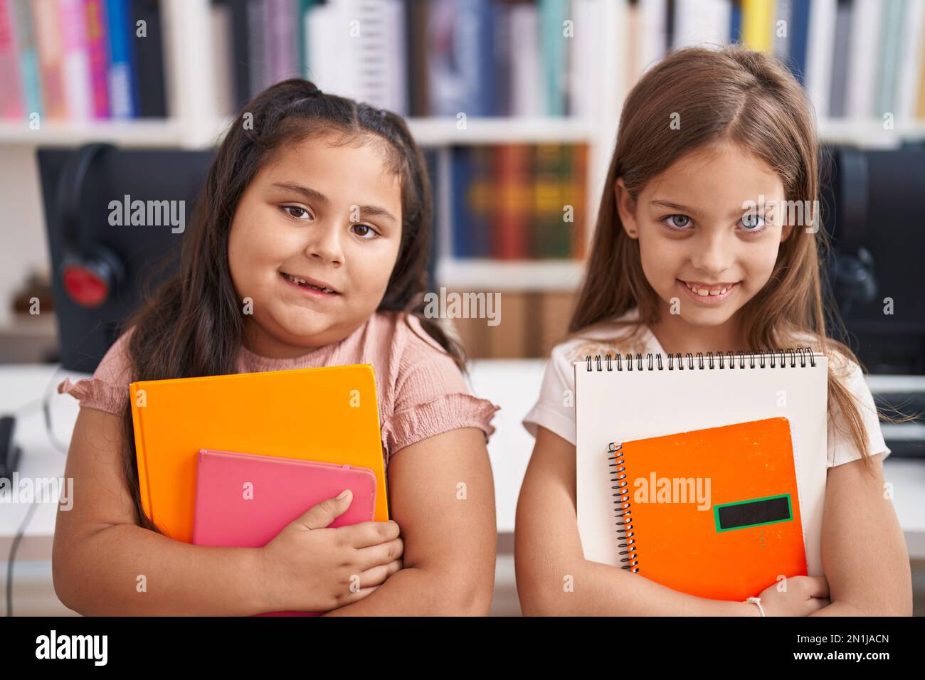 Two kids students smiling confident holding books at classroom Stock ...